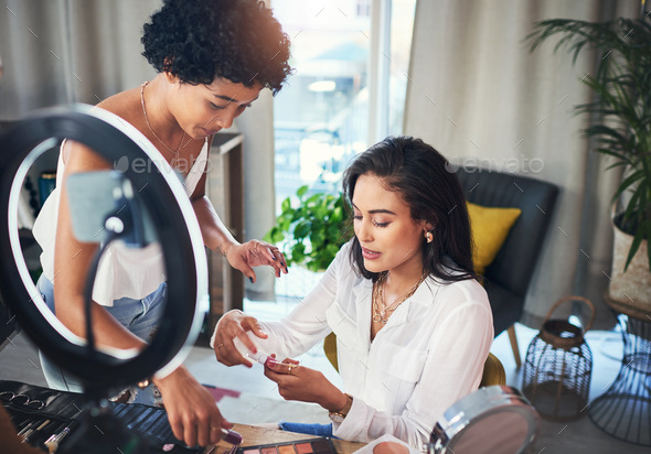 Shot of two women doing a makeup tutorial for their blog Stock Photo by ...