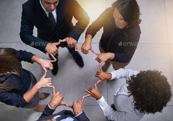 High angle shot of a group of coworkers making a shape with their hands ...