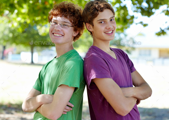 Weve got each others backs. Portrait of two boys standing back to back ...