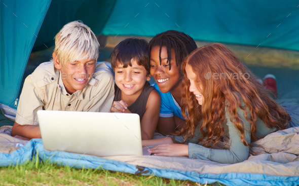 Children enjoying using a laptop while out camping in a tent Stock ...