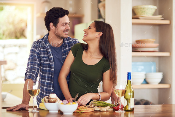 Can I kiss the cook. Shot of a young couple preparing dinner together ...