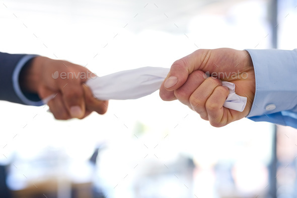 Cropped shot of two businessmen fighting over a crumpled up document ...