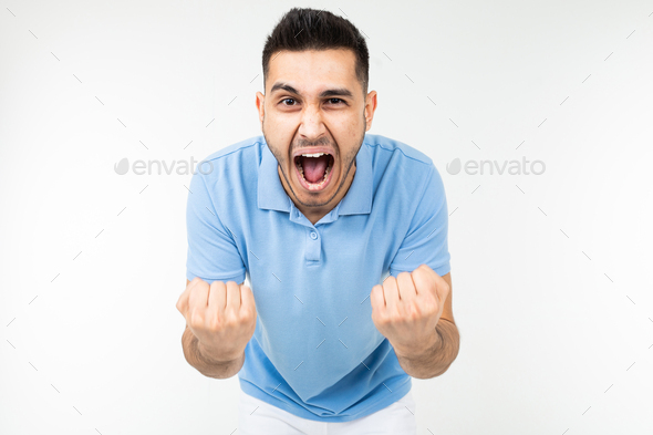 handsome caucasian man in a blue t-shirt holds fists for good luck on a ...
