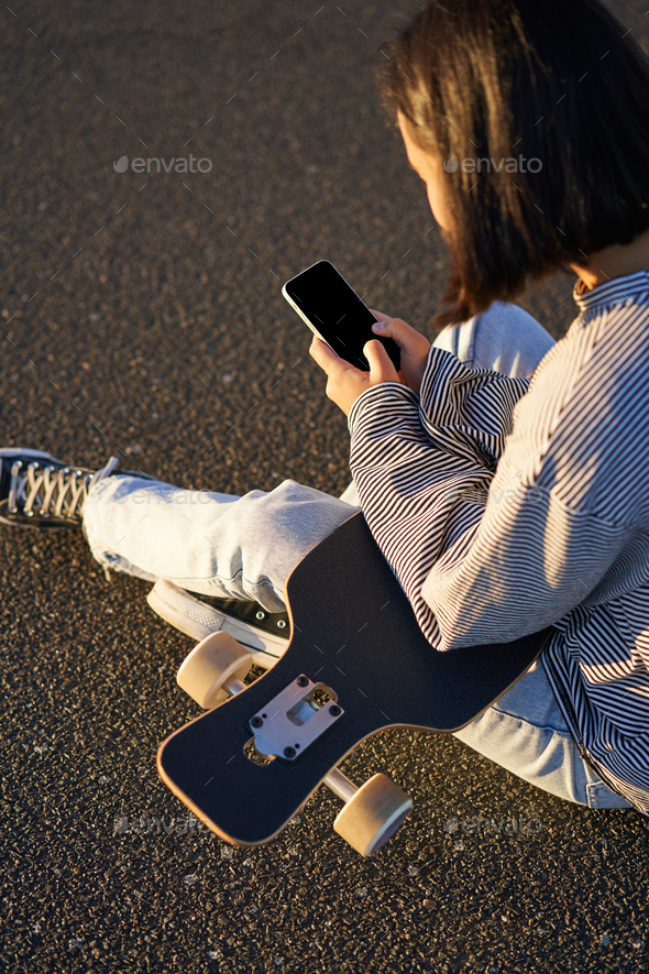 Vertical shot of asian girl typing, sending message or using mobile ...