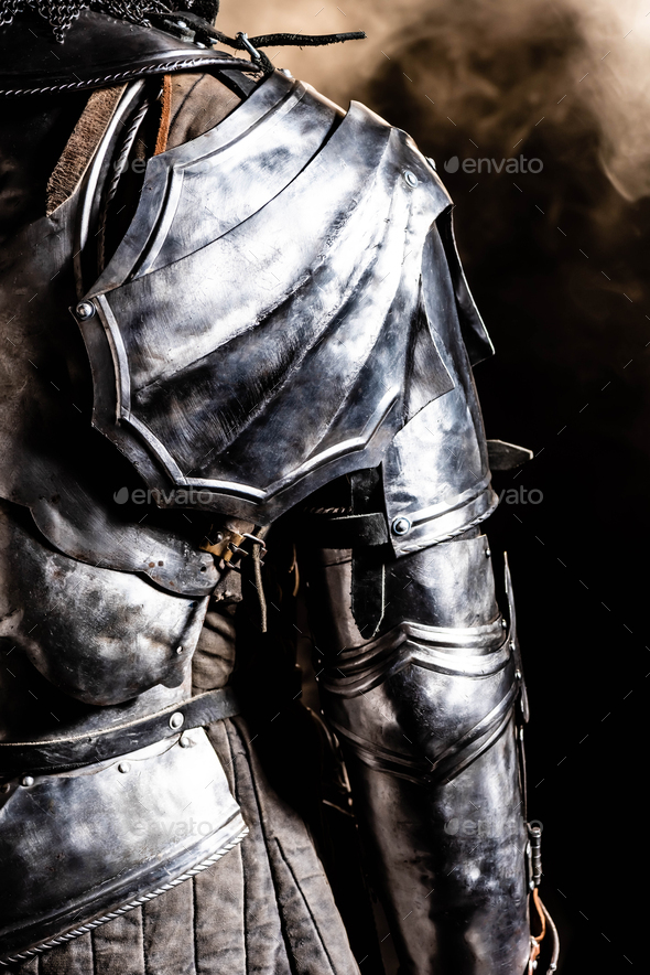 cropped view of knight in armor on black background Stock Photo by ...