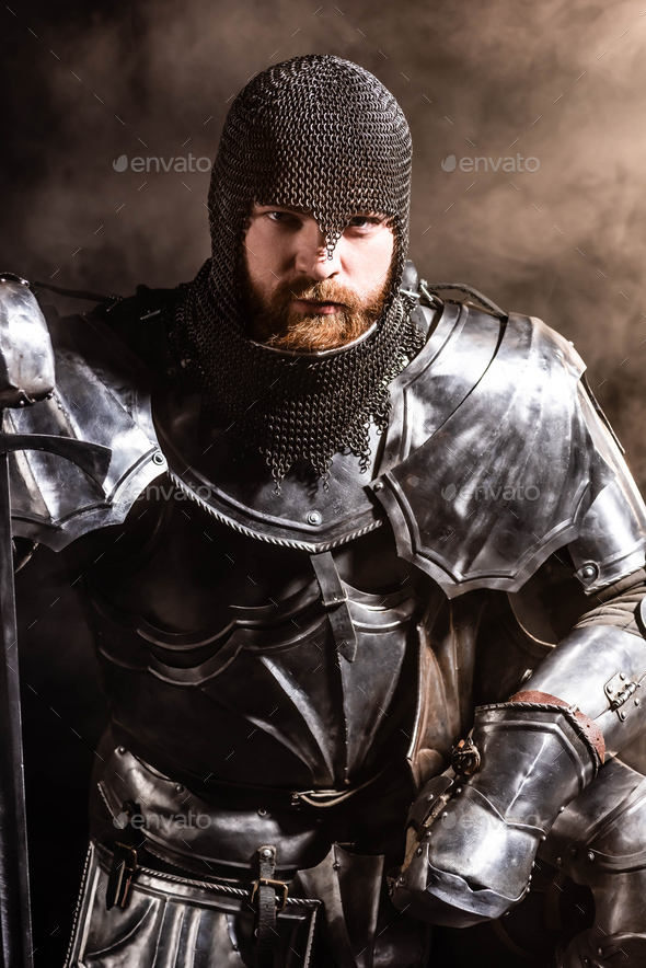 handsome knight in armor holding sword on black background Stock Photo ...