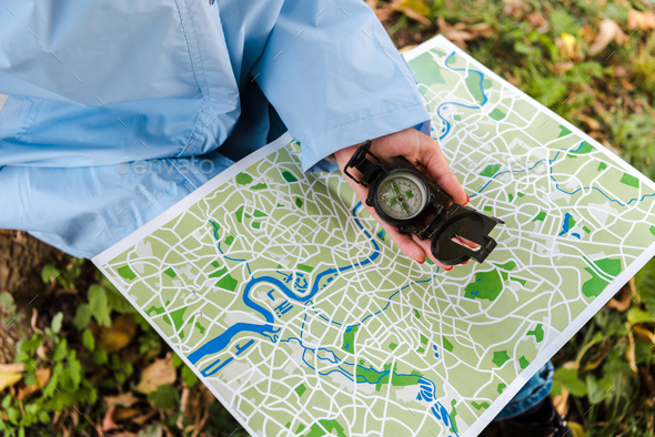 cropped view of traveler holding map and compass outside Stock Photo by ...