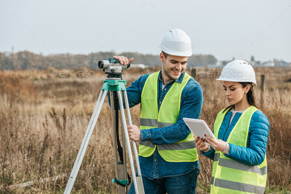 Surveyors working with digital level and tablet in field Stock Photo by ...