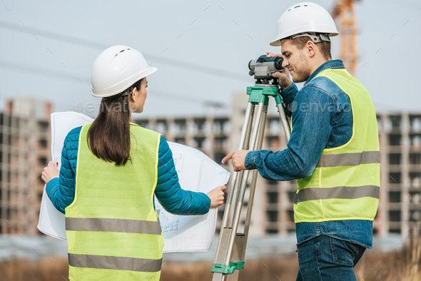 Surveyors working with blueprint and digital level Stock Photo by ...
