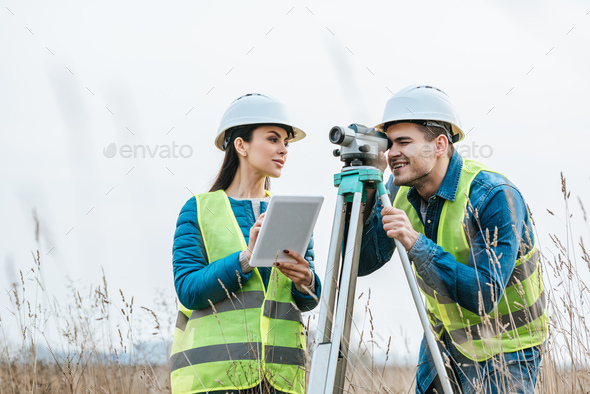 Surveyors working with digital level and tablet in field Stock Photo by ...