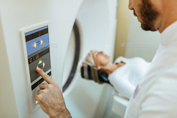 Close-up of radiologist starting CT scan procedure of a patient at ...