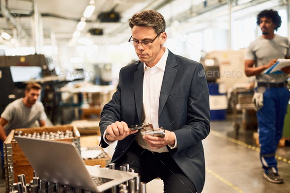 Quality control inspector measuring steel bolt with a caliper in ...