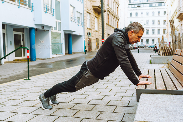 Middle-aged man is engaged in muscle pumping, sports training Stock ...