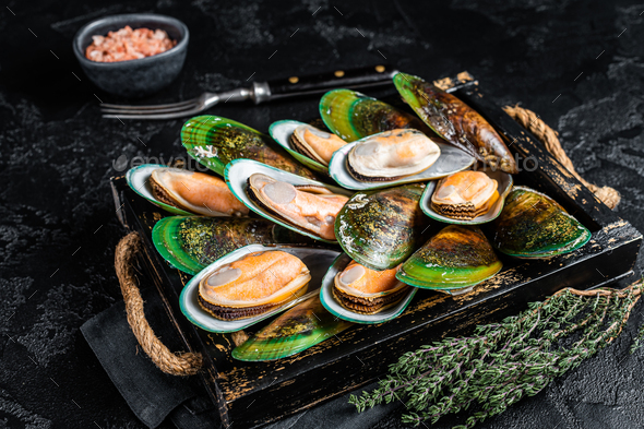 Boiled Green mussels with herbs in a wooden tray. Black background. Top ...