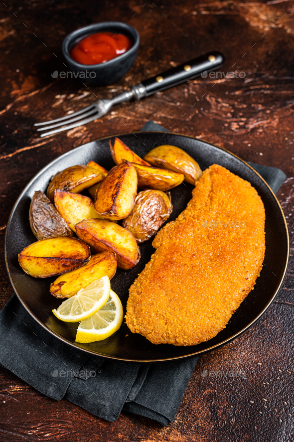 Roast pork schnitzel with fried potato, cooked meat steak. Dark ...