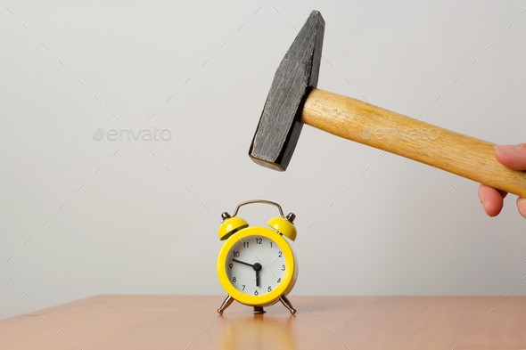 The hammer breaks the alarm clock. Tap the hammer on the alarm clock ...