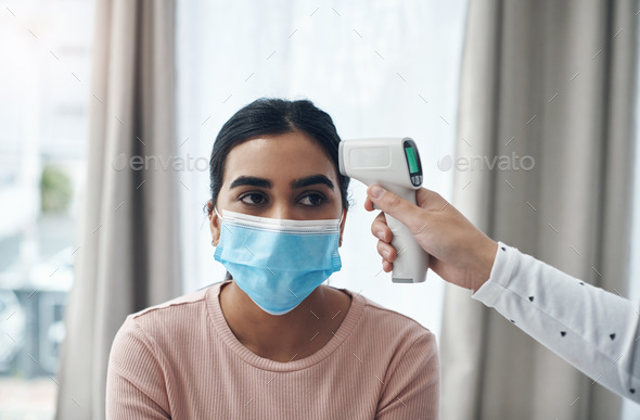 Shot of an unrecognizable doctor using a thermometer to take a patients ...
