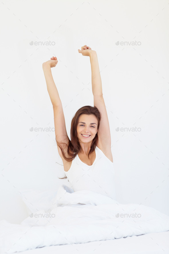 Feeling vitalized and refreshed. A smiling girl waking up and ...