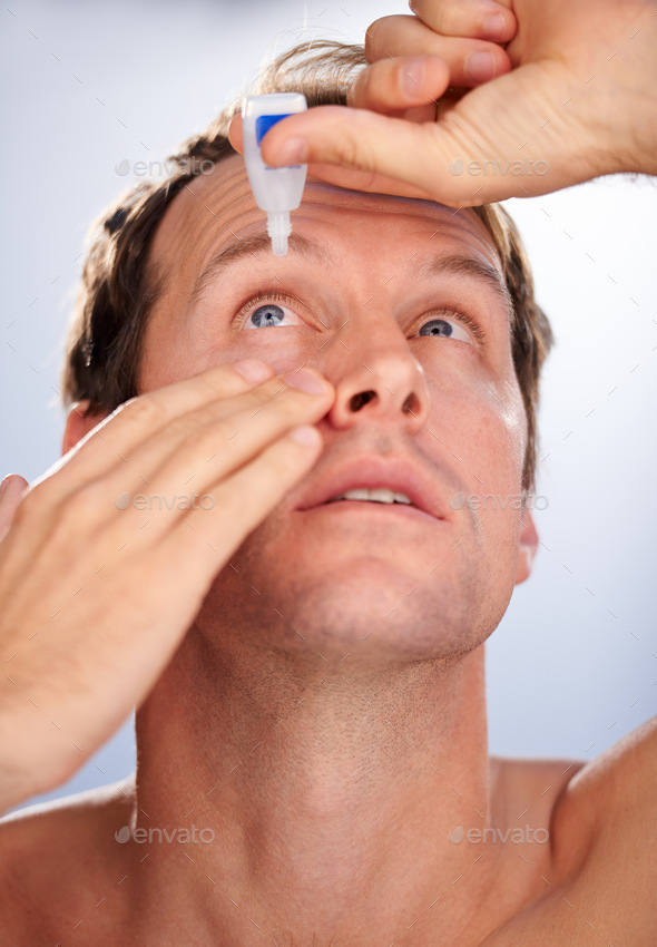 Adding a little sparkle. Cropped studio shot of a man adding eye drops ...