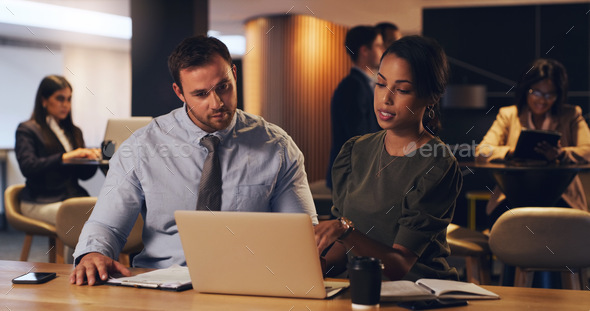 Shot of two businesspeople working together on a laptop in an office at ...