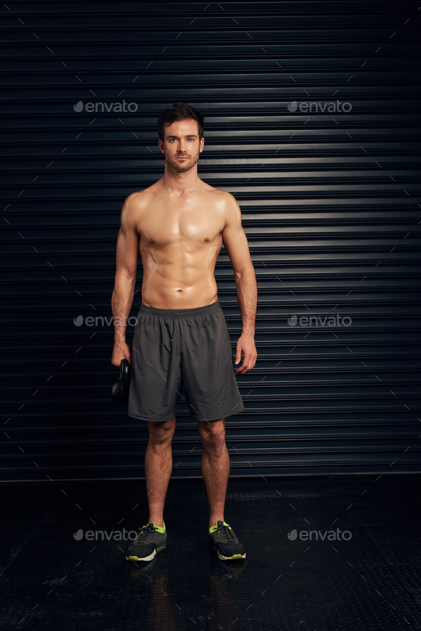 Studio portrait of a shirtless and well built man standing against a ...