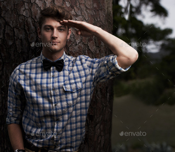 Portrait of a handsome young man saluting the camera while standing ...