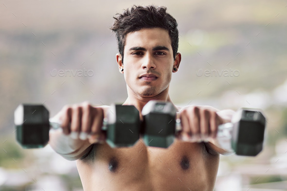 No pain, no gain. Portrait of a shirtless young man working out with ...