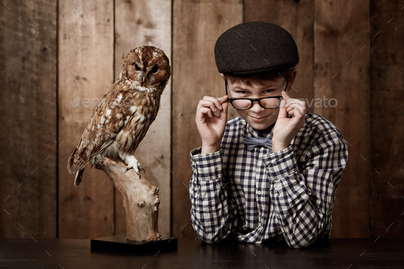 Young boy in retro clothing wearing spectacles with a stern expression ...