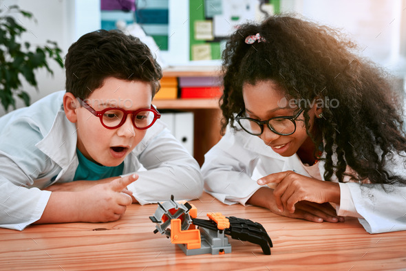 Shot of an adorable little boy and girl building a robot in science ...