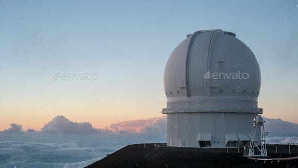 Modern observatory building on top of a mountain with clouds in the ...