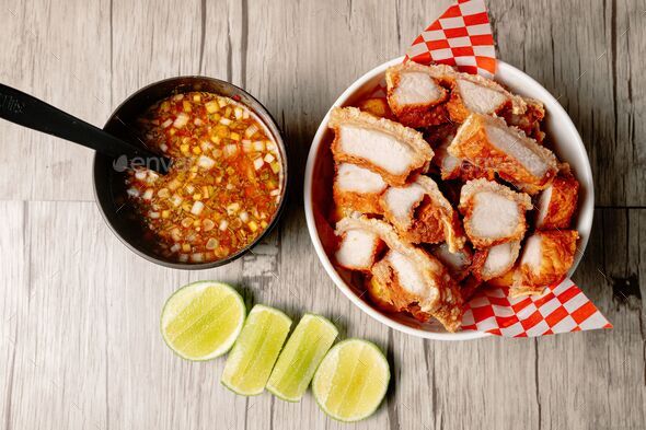 Top view of Lechon kawali pork belly slabs and a bowl of vegetable soup ...