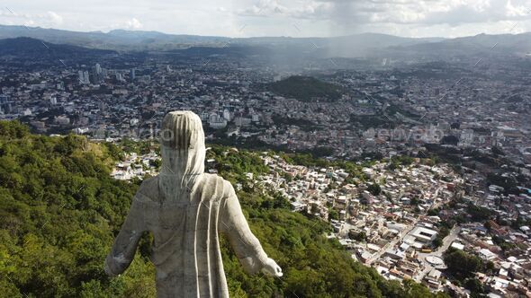 Drone shot of the Christ of the Peak statue over the cityscape in ...