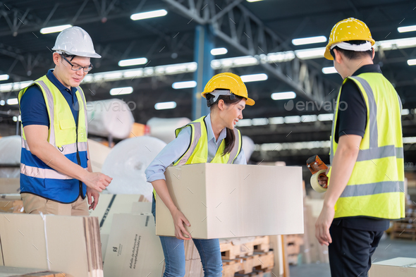Staff in large storage warehouse together packing goods and carry ...