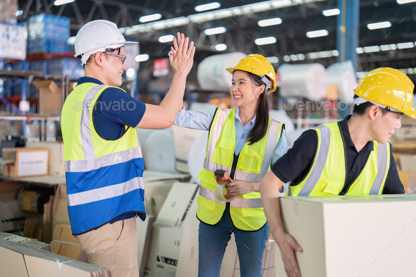 Staff in large storage warehouse together packing goods and carry ...