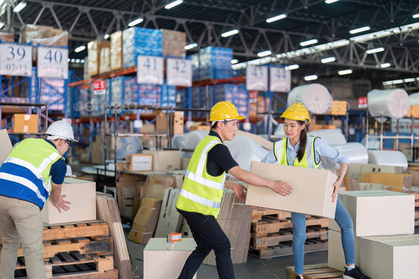 Staff in large storage warehouse together packing goods and carry ...