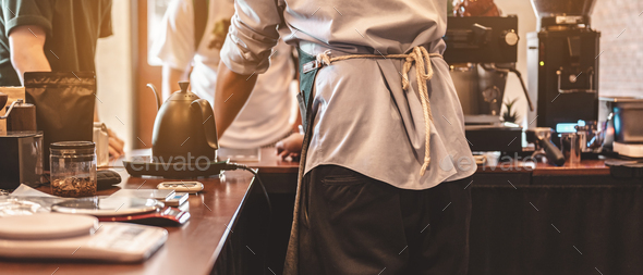 The back view of the barista in the bar counter at the coffee shop ...