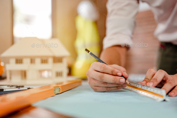 Close up of male architect hands measuring and making model house on ...