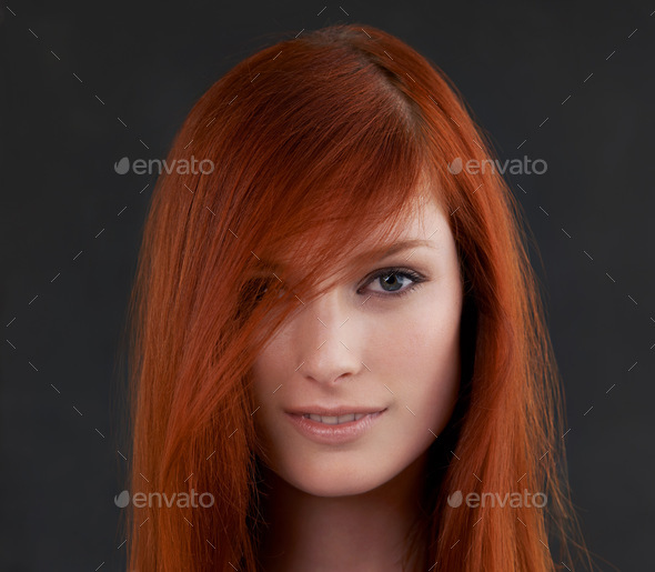 Simply red. Portrait of a gorgeous young redheaded woman against a ...