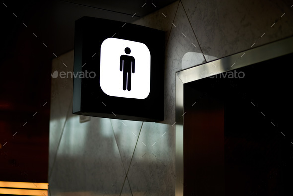 Low angle shot of the sign in a public building indicating above a male ...