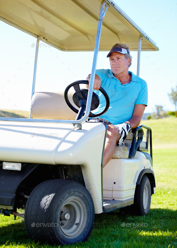 Golf i. A mature man driving a cart over the golf course. Stock Photo ...