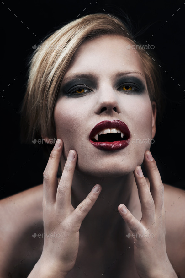 Creature of the night. A seductive female vampire with blood red lips ...