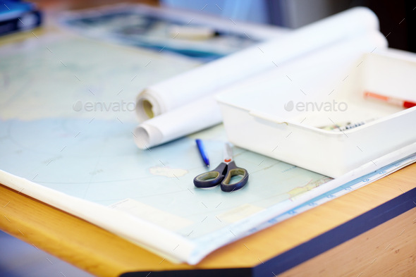 High angle shot of a map and stationary lying on a desk inside a ...