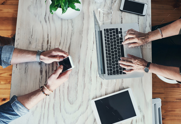 High angle shot of two unrecognizable businesspeople working at a desk ...