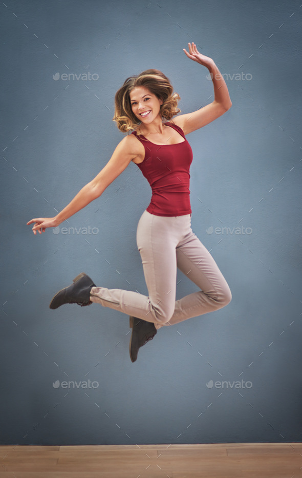 Footloose and fancy free. Shot of a happy young woman jumping in the ...