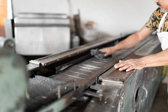 An adult tortilla maker is the conveyor belt of the nixtamal mill to ...