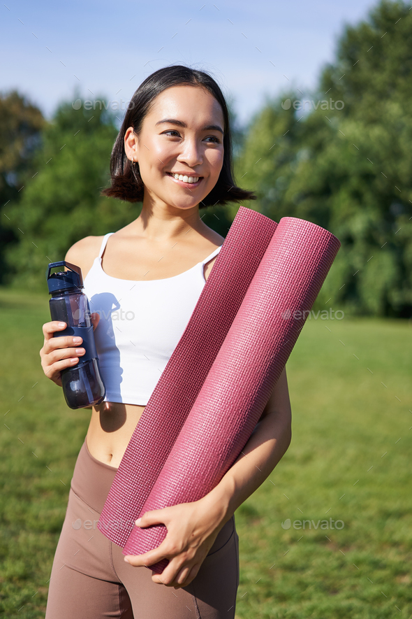 Portrait of young slim and healthy korean girl doing workout in park ...