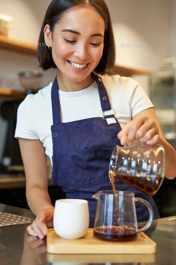 Barista in cafe pouring filter coffee, brewing and preparing order ...