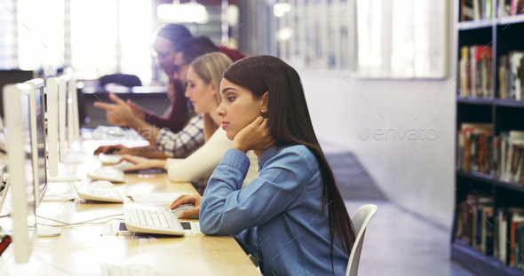 Cropped shot of university students studying using the computers in the ...