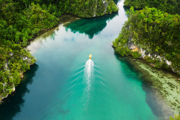 High angle shot of a boat sailing through a canal running along the ...