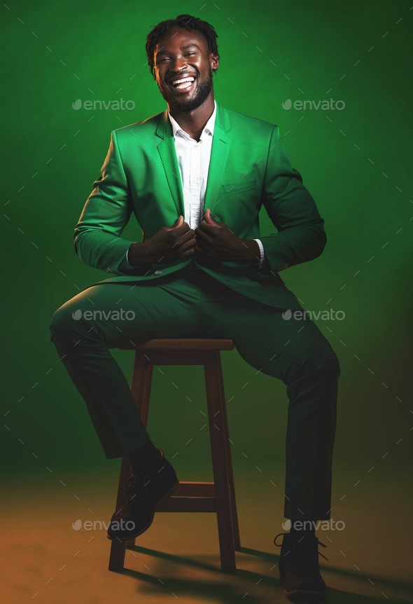 Fashion, trendy and black man model in a suit on chair in the studio ...